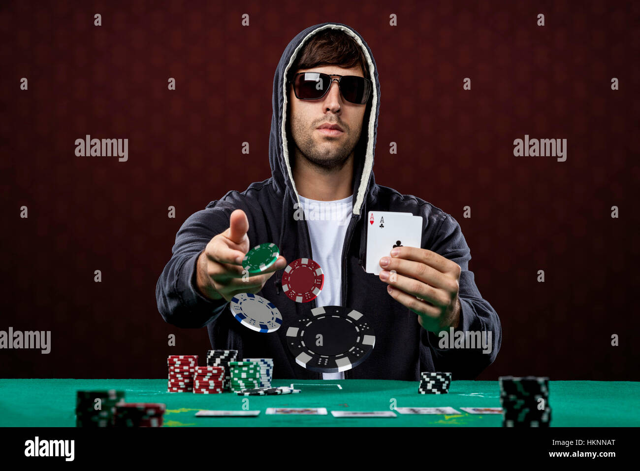 Poker player, on a red background, throwing poker chips Stock Photo - Alamy