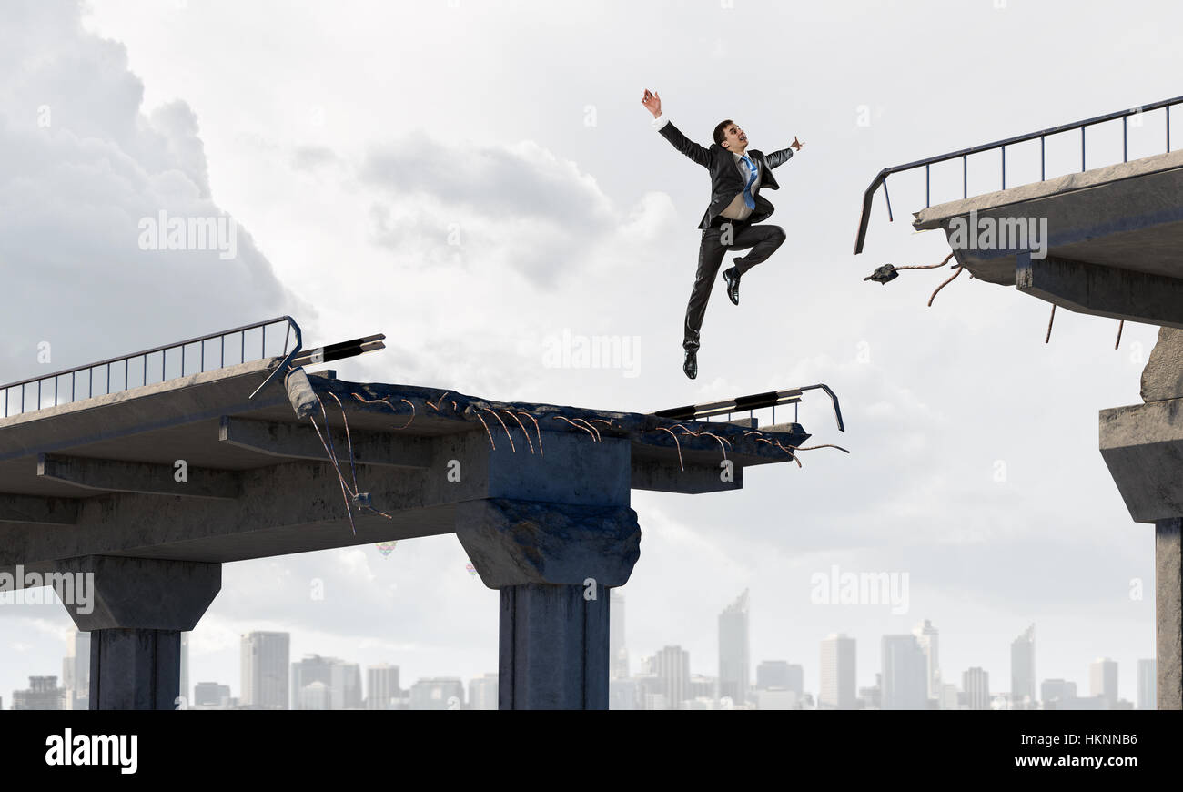 Businessman jumping over a gap in bridge as symbol of problem ...