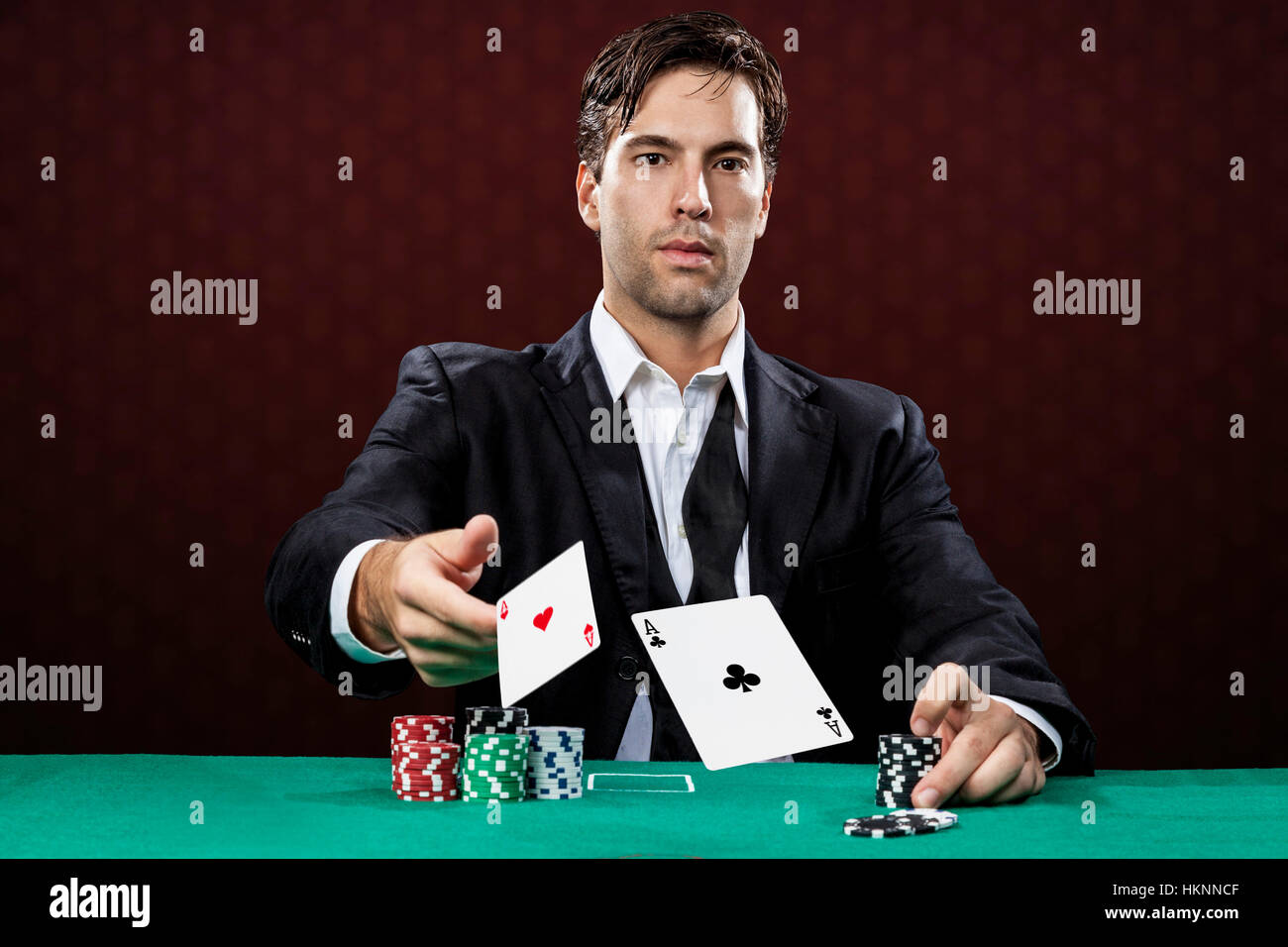Poker player, on a red background, throwing two ace cards Stock Photo ...