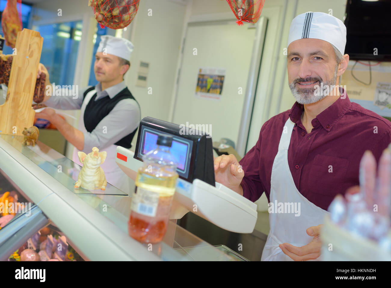 Men serving at butchers counter Stock Photo - Alamy