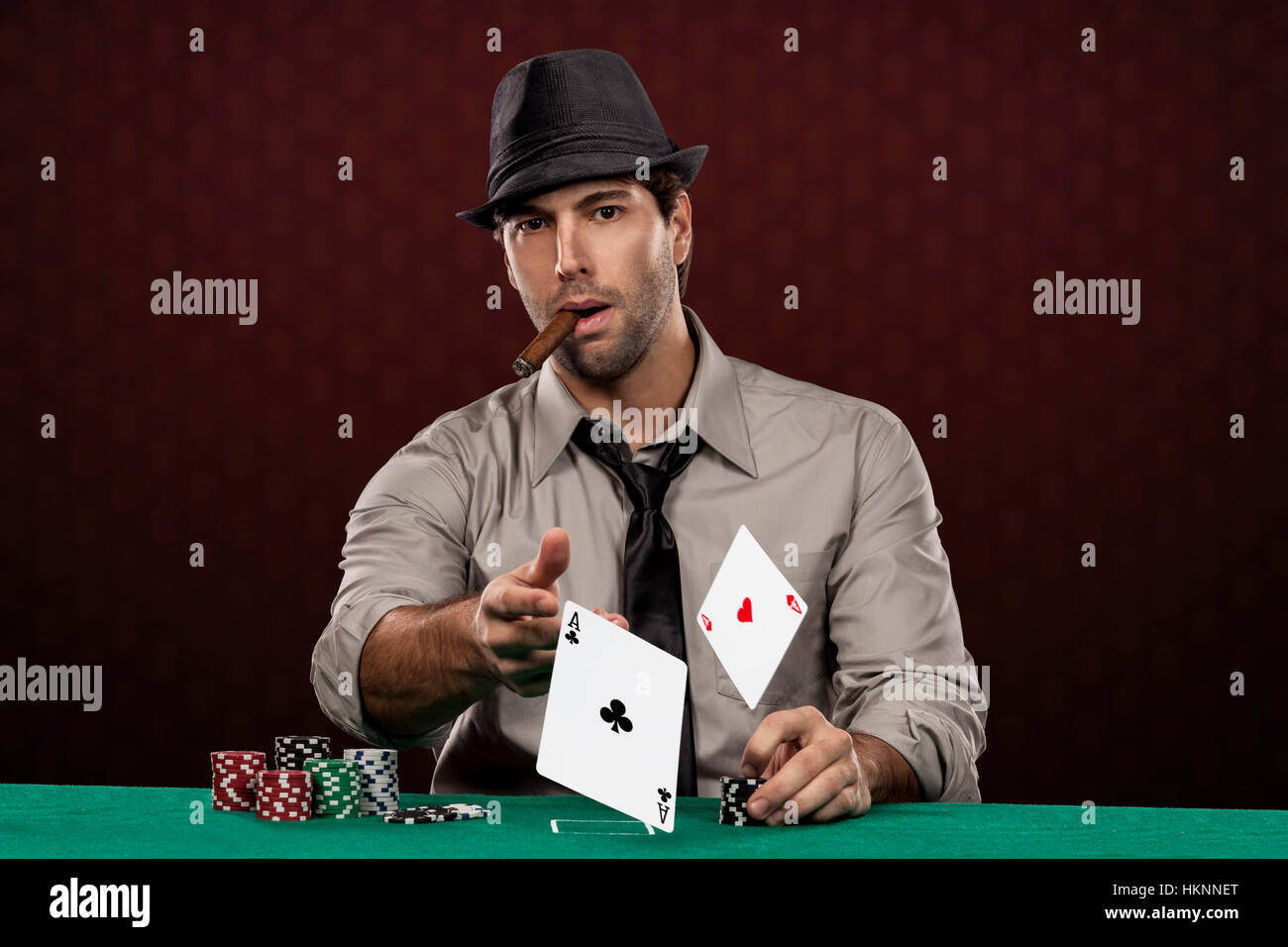 Poker player, on a red background, throwing two ace cards Stock Photo ...