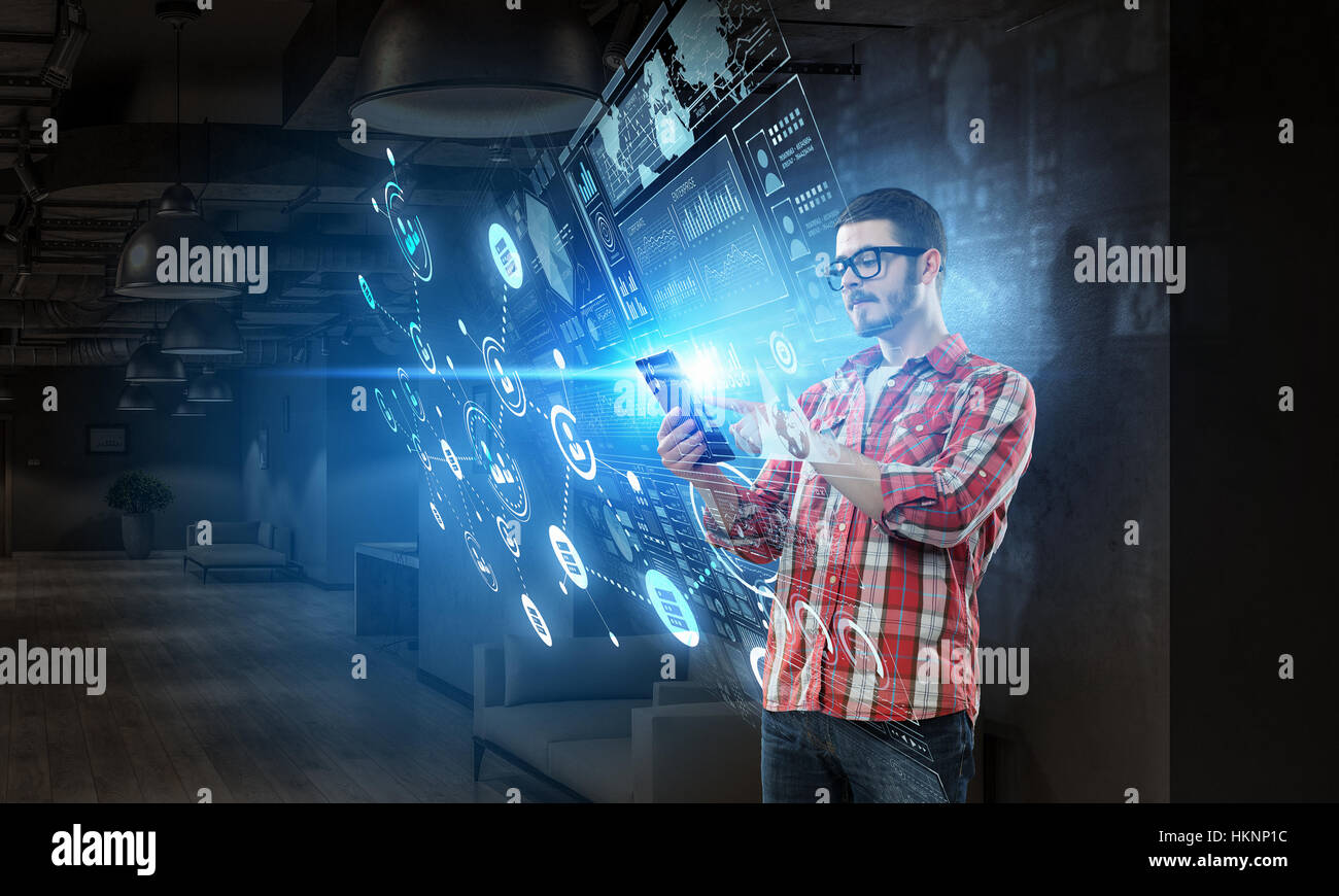 Hipster guy against media technologies background using tablet device ...