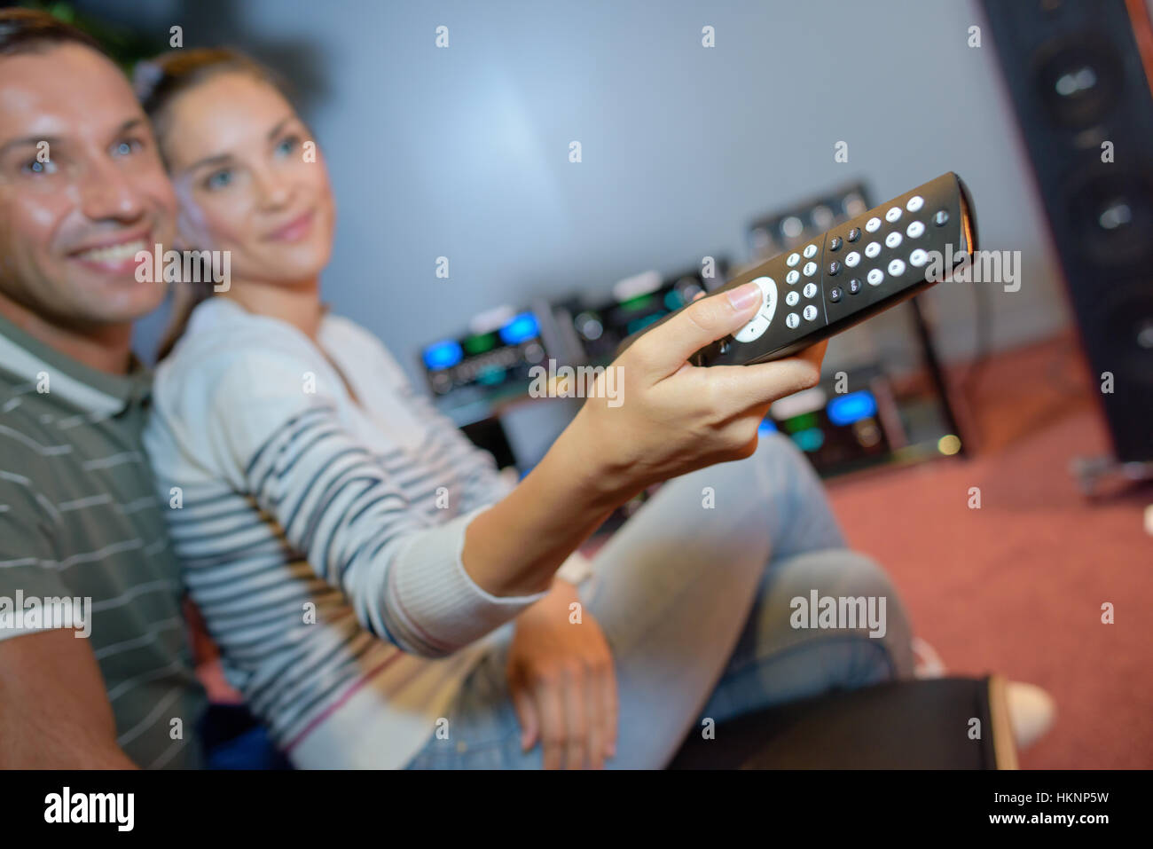 Lady pressing remote control Stock Photo - Alamy