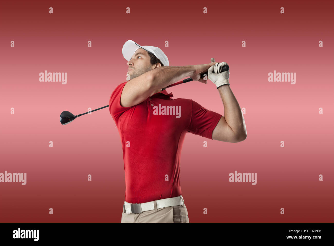 Golf Player in a red shirt taking a swing, on a red Background Stock ...