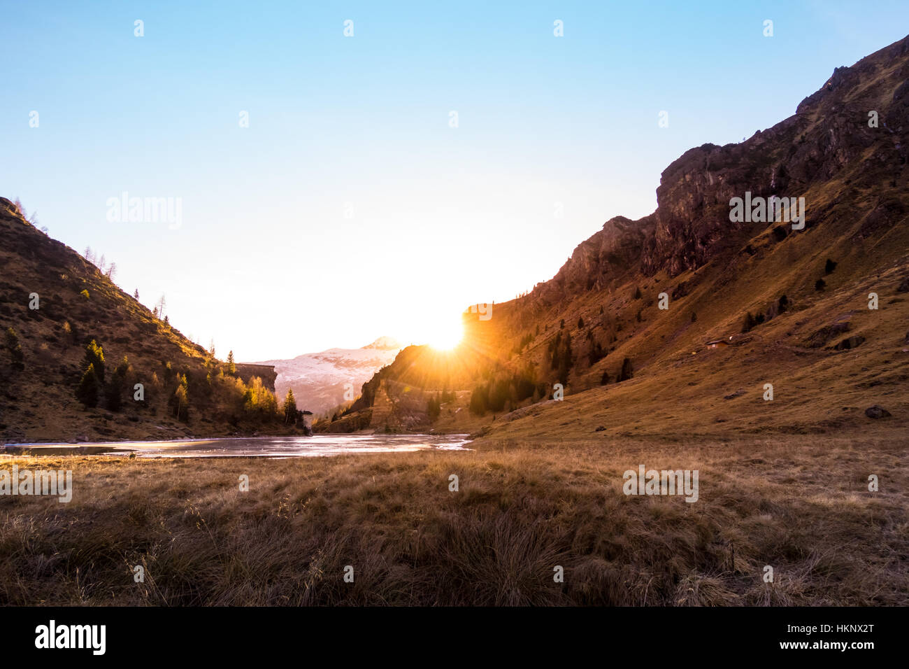 Sunset in a valley between mountains with small river Stock Photo - Alamy