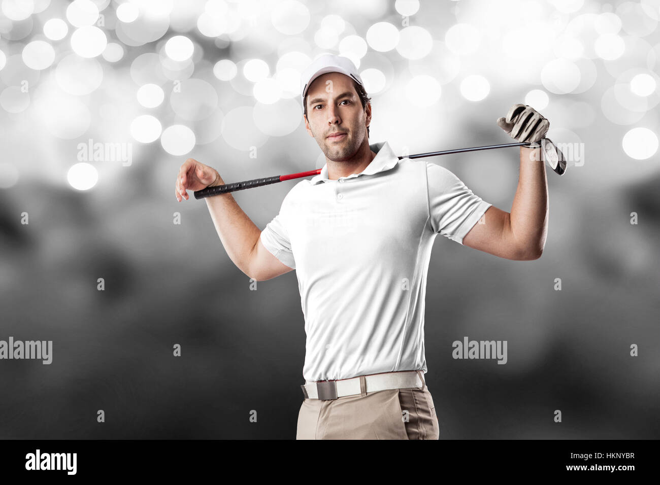 Golf Player in a white shirt taking a swing, on a white lights ...