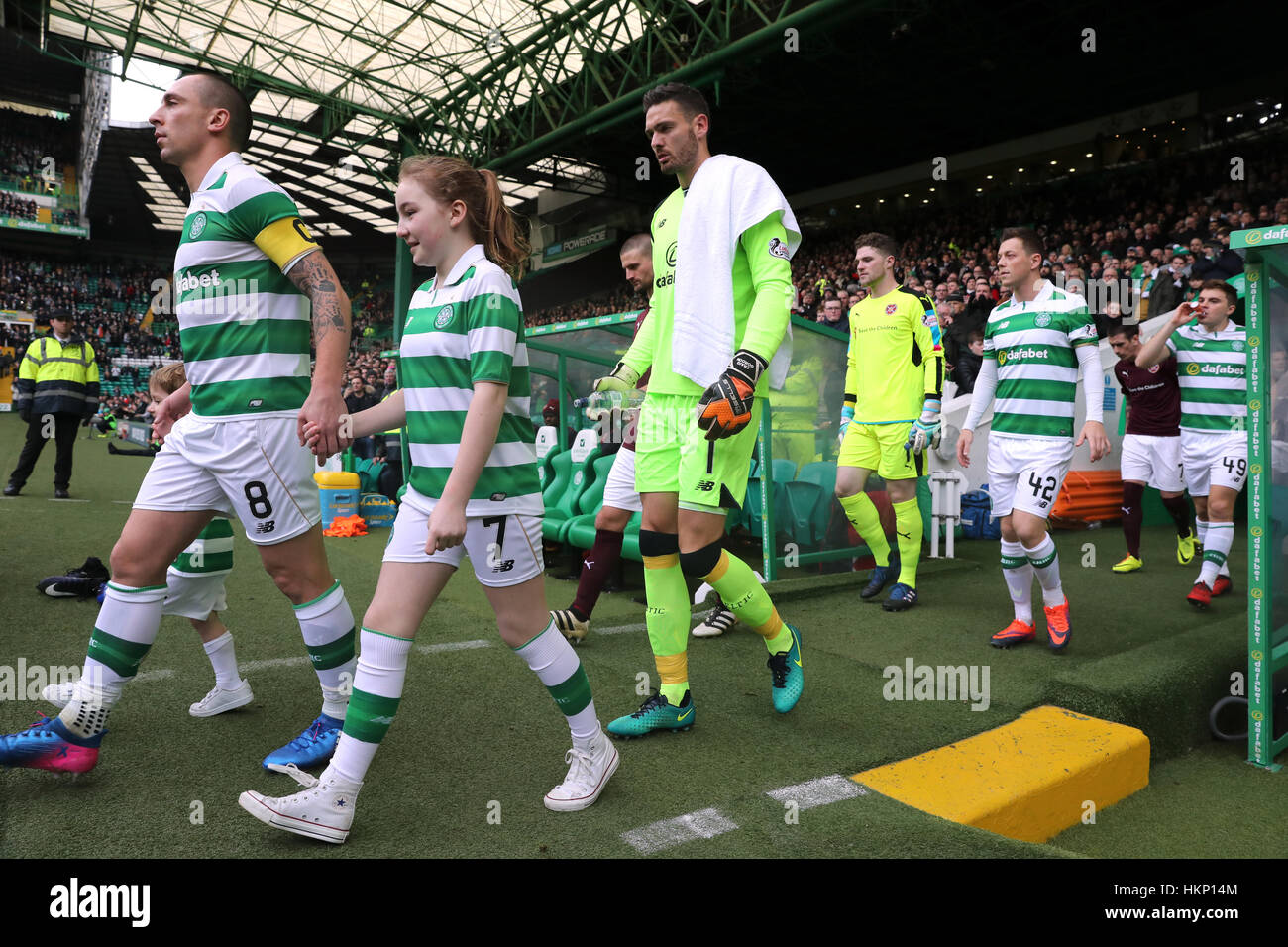 Celtic players and Hearts players walk out onto the pitch before the ...
