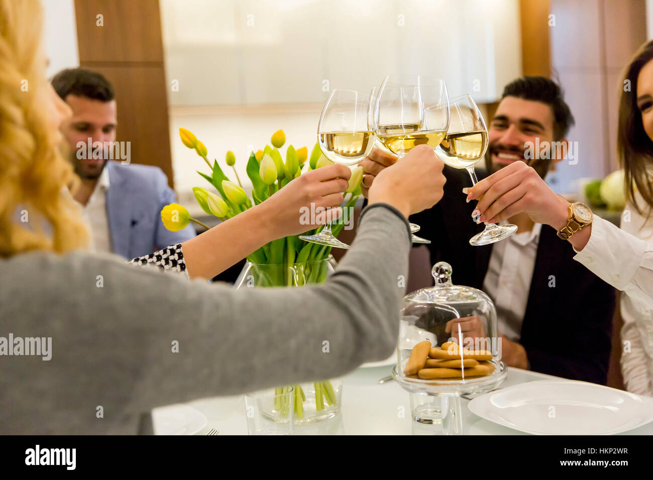Friends interacting while having a meal at dining table and toast with ...