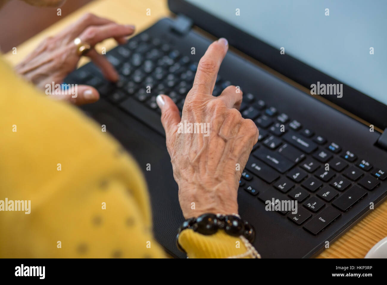 Elderly woman's hands and laptop Stock Photo - Alamy