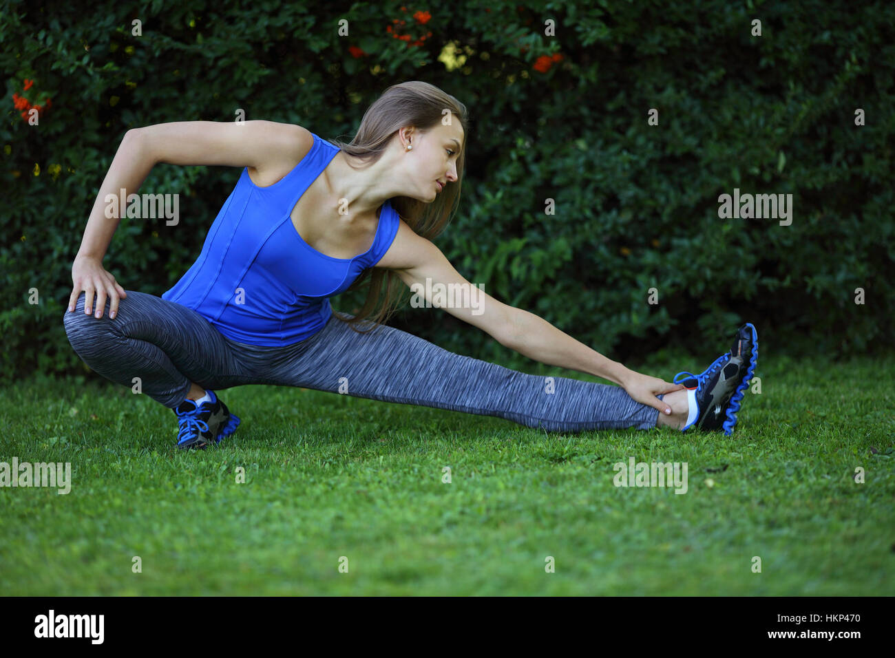 Young fitness girl trains stretching outdoors on grass Stock Photo - Alamy