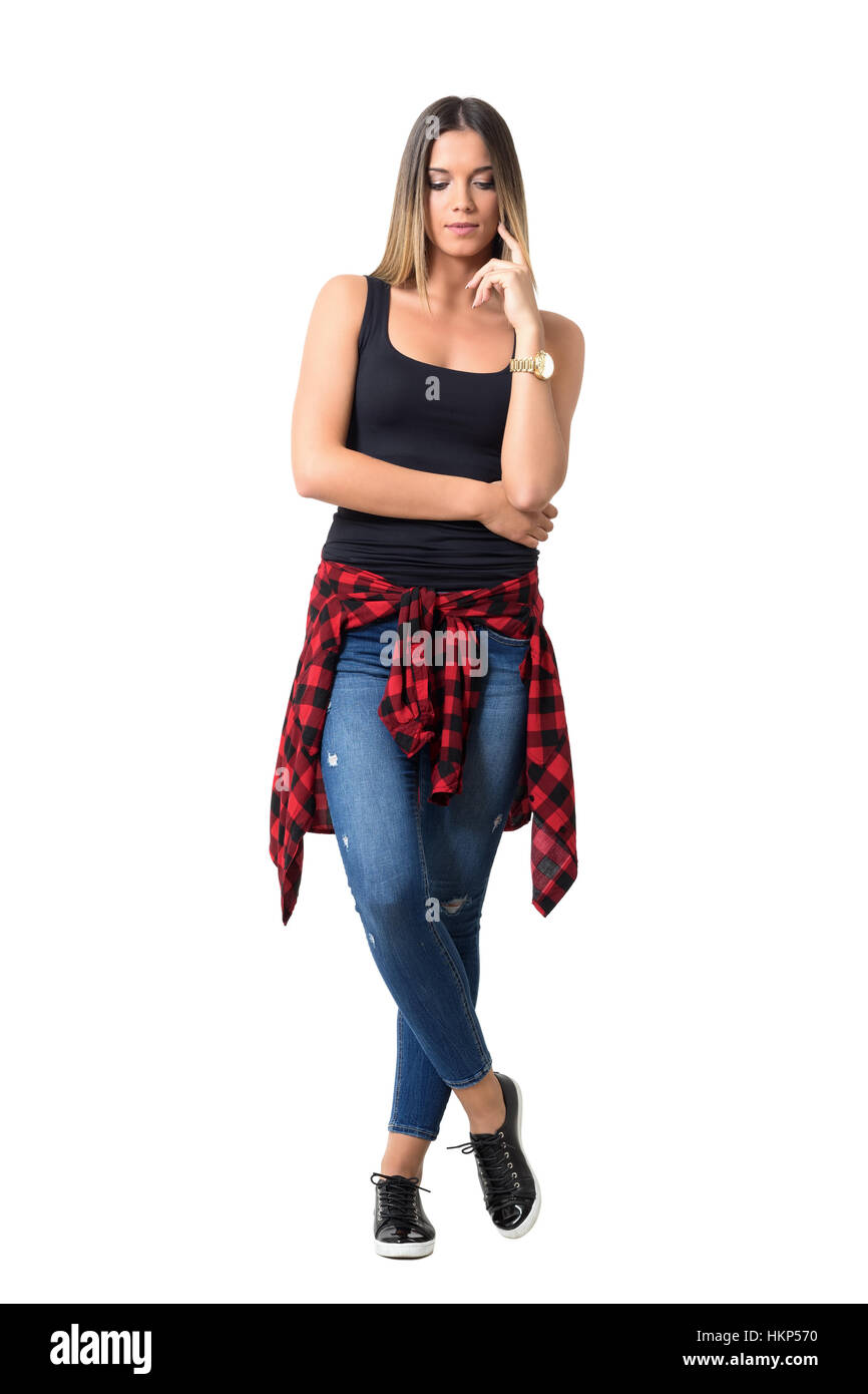 Sad young casual woman in street style clothing looking down. Full body ...
