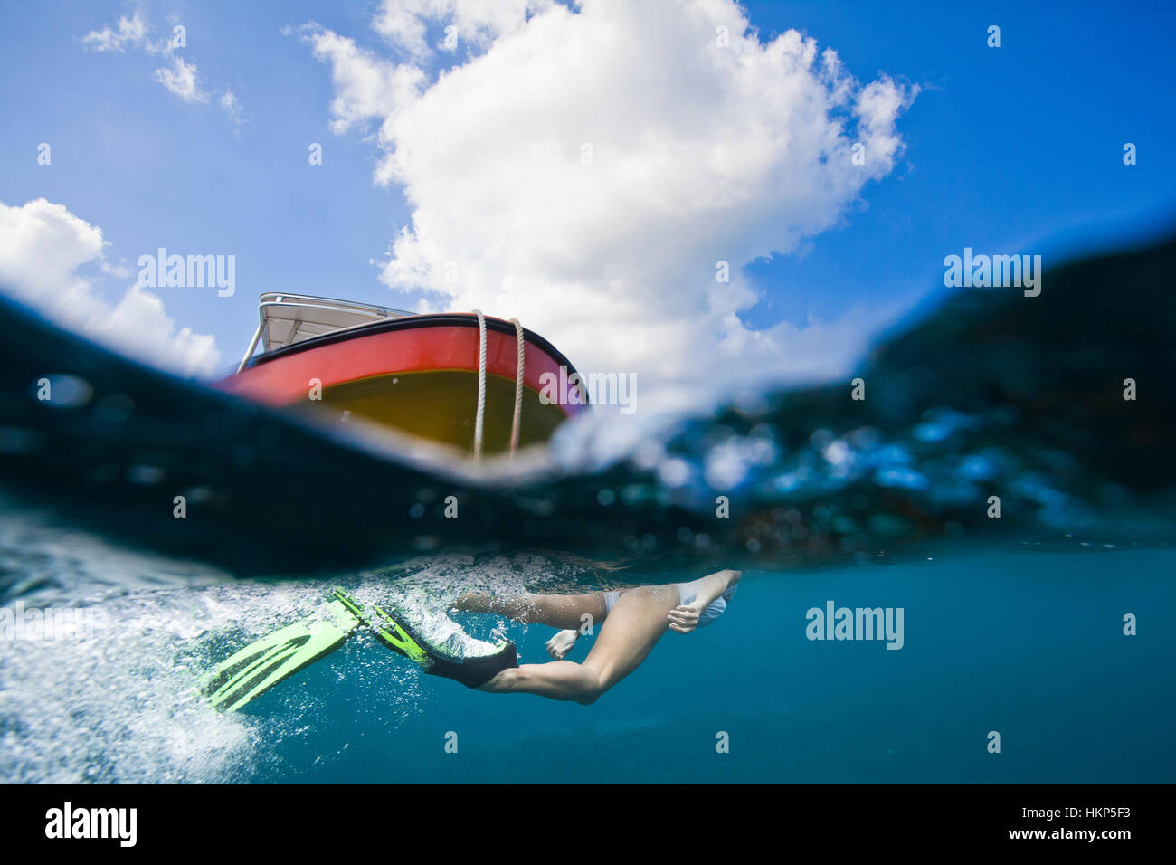 A Split Shot of a woman swimming in front of a bow of a boat Stock ...