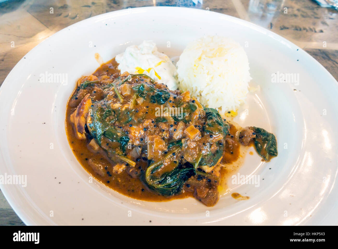 Hake fish curry served with rice and yoghurt Stock Photo - Alamy