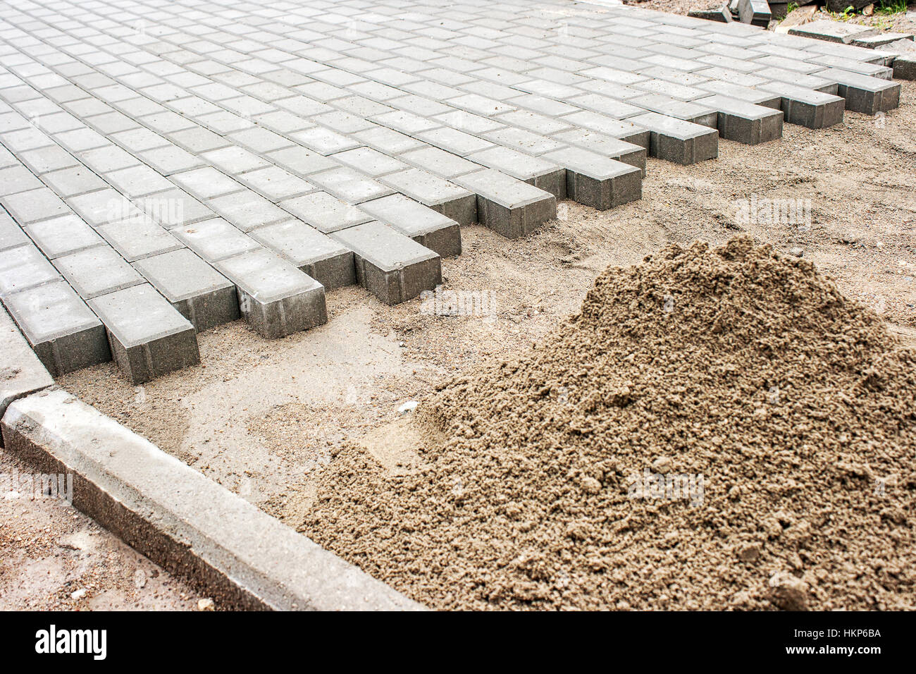 construction of a new pavement of paving slabs on summer day closeup ...