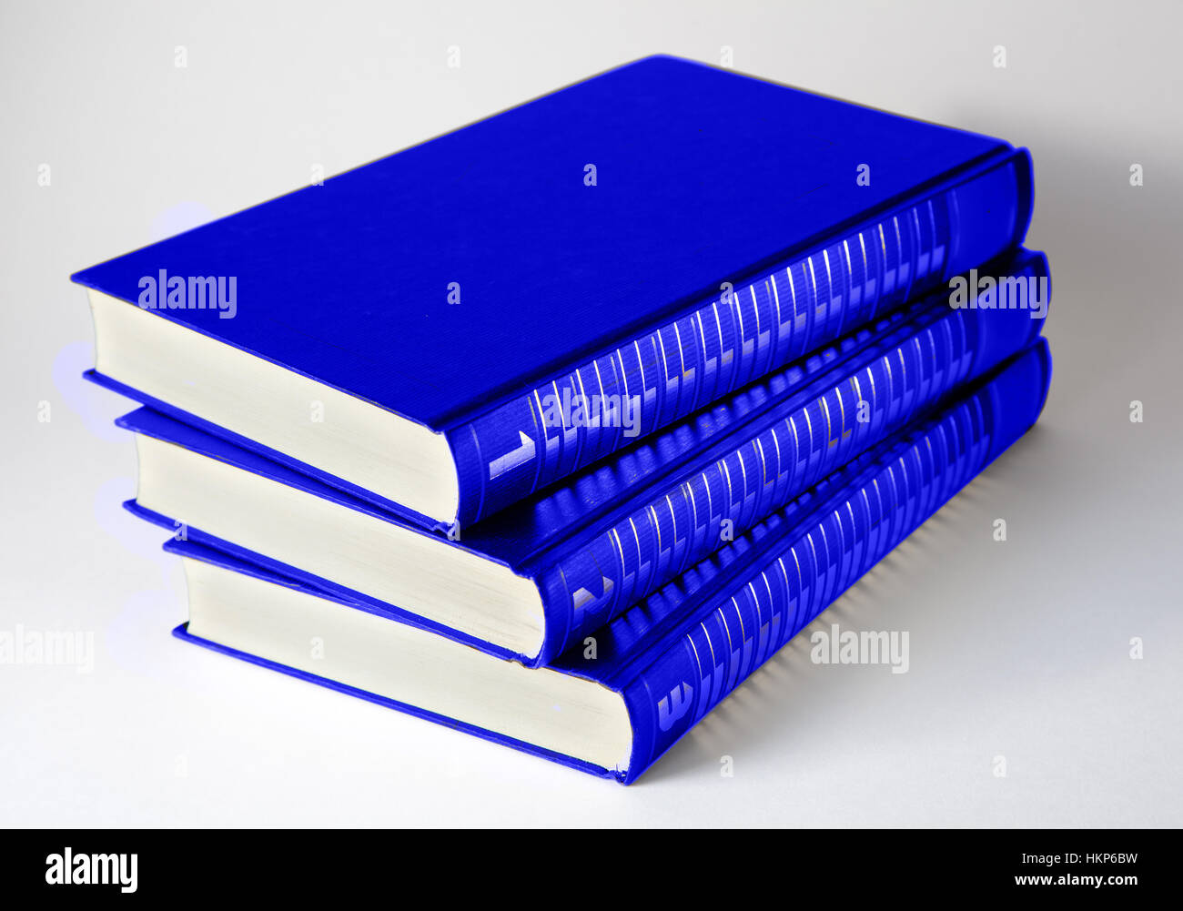 three books in blue covers on light background closeup Stock Photo - Alamy