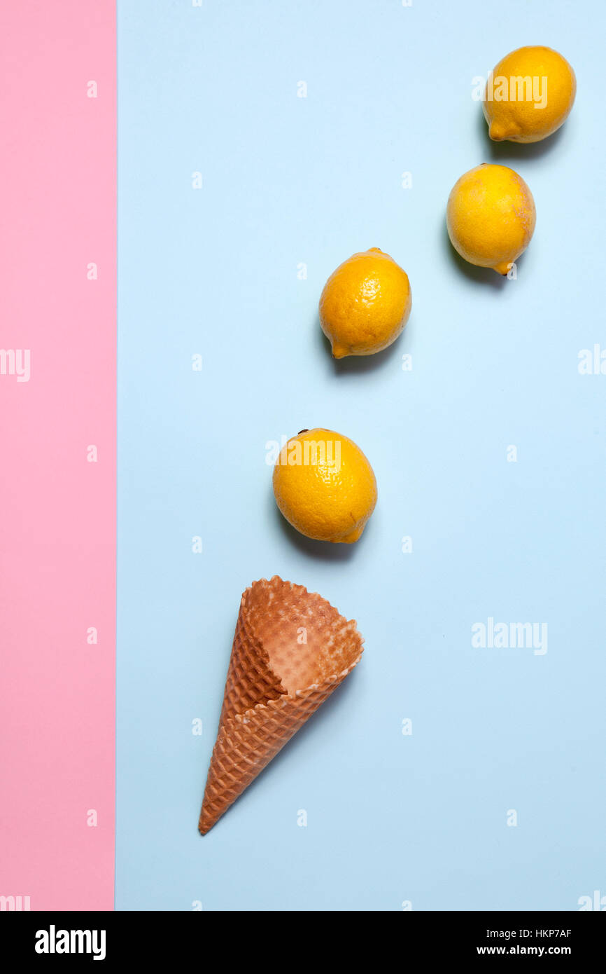 still life with cone, lemon and spoon at pink and blue background Stock ...
