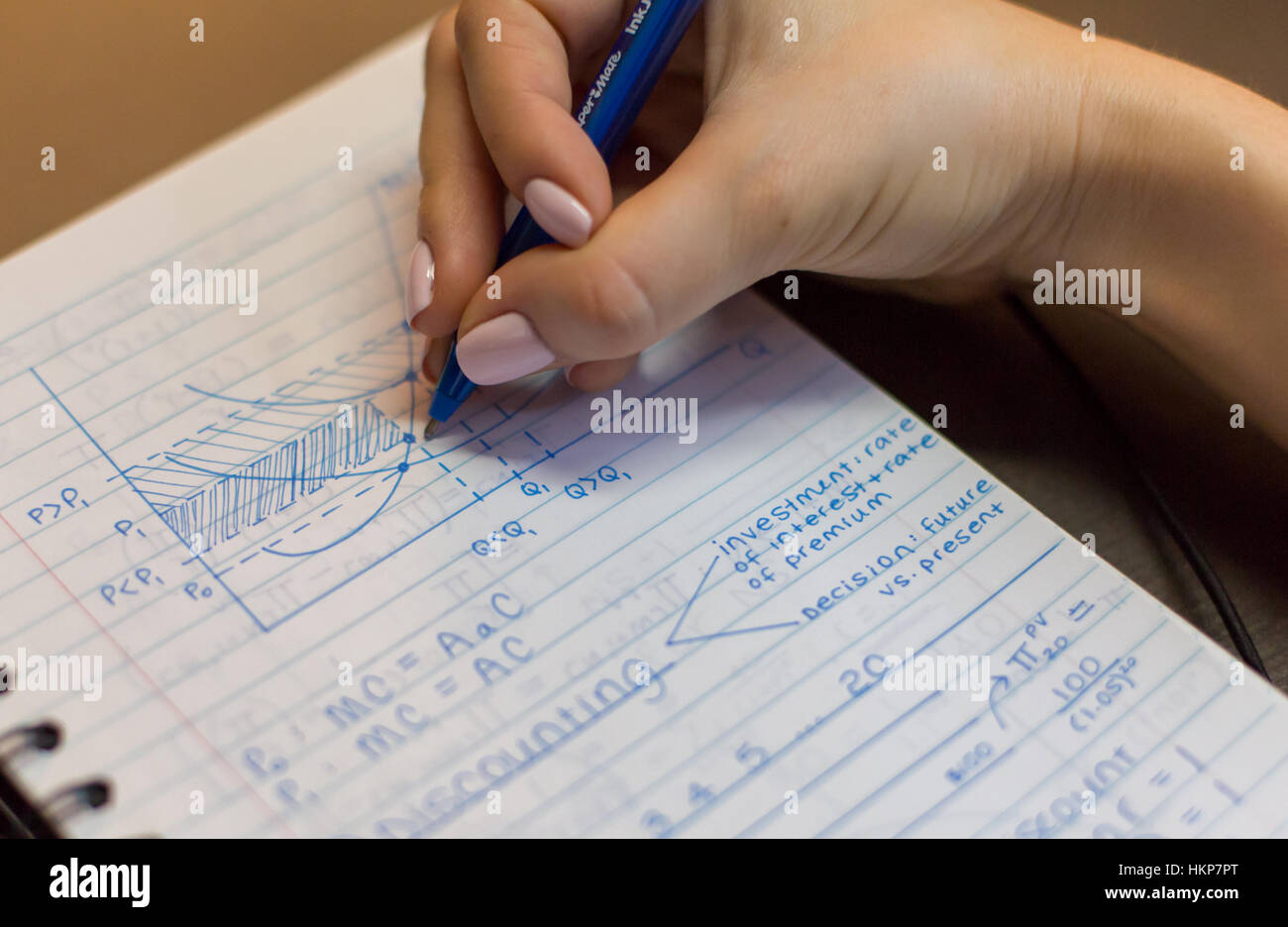 Female student drawing a graph in economics class Stock Photo - Alamy
