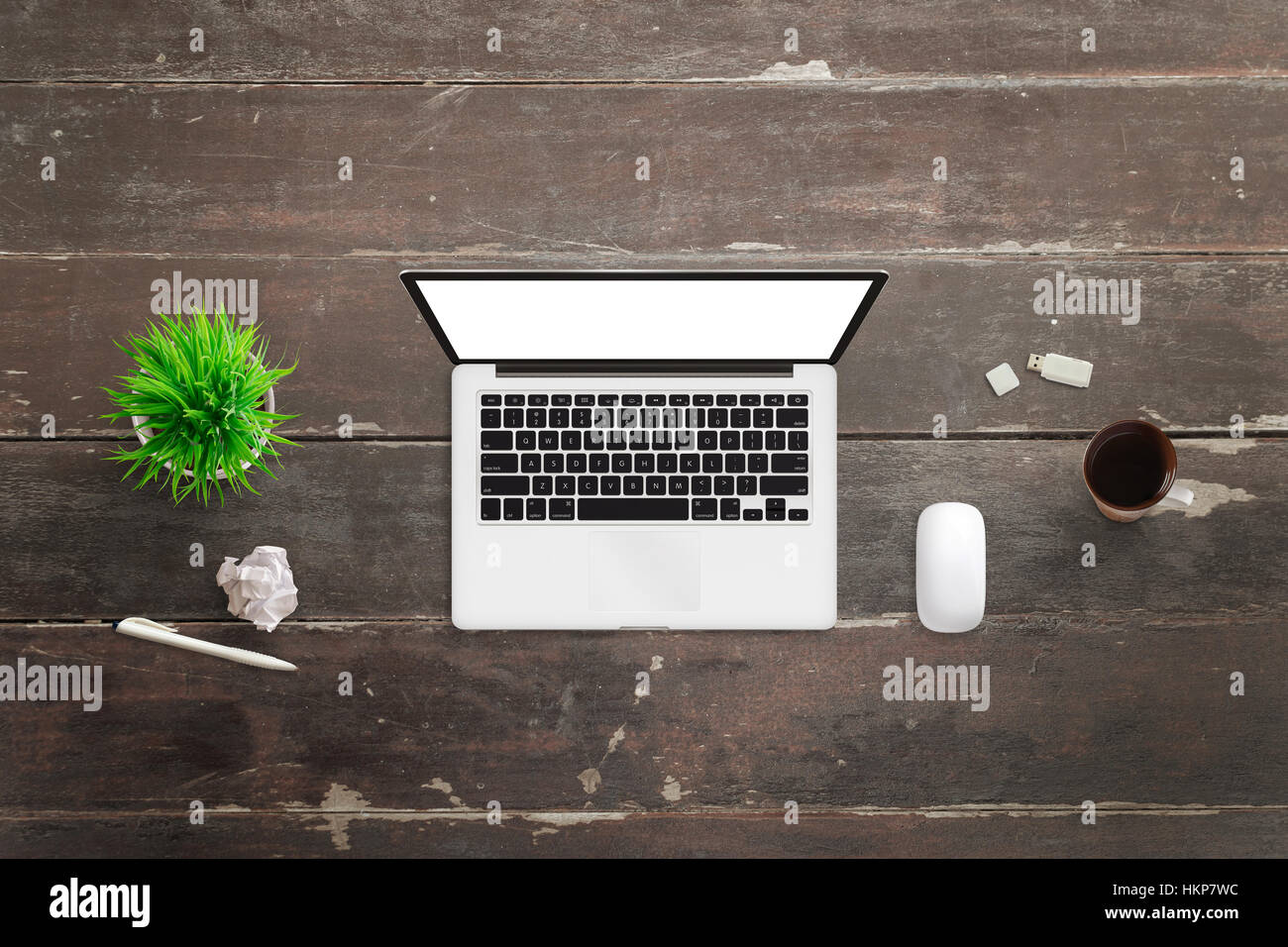 Top view of laptop computer on wooden desk. Coffee and plant beside ...
