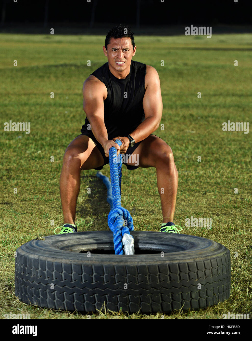 sport man pull tire on green grass in park Stock Photo - Alamy