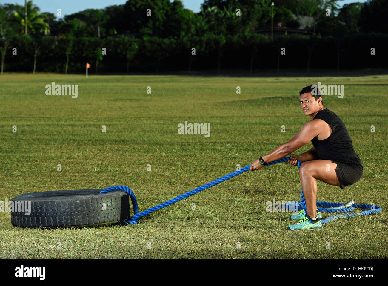sport man workout with tire on green grass park Stock Photo - Alamy