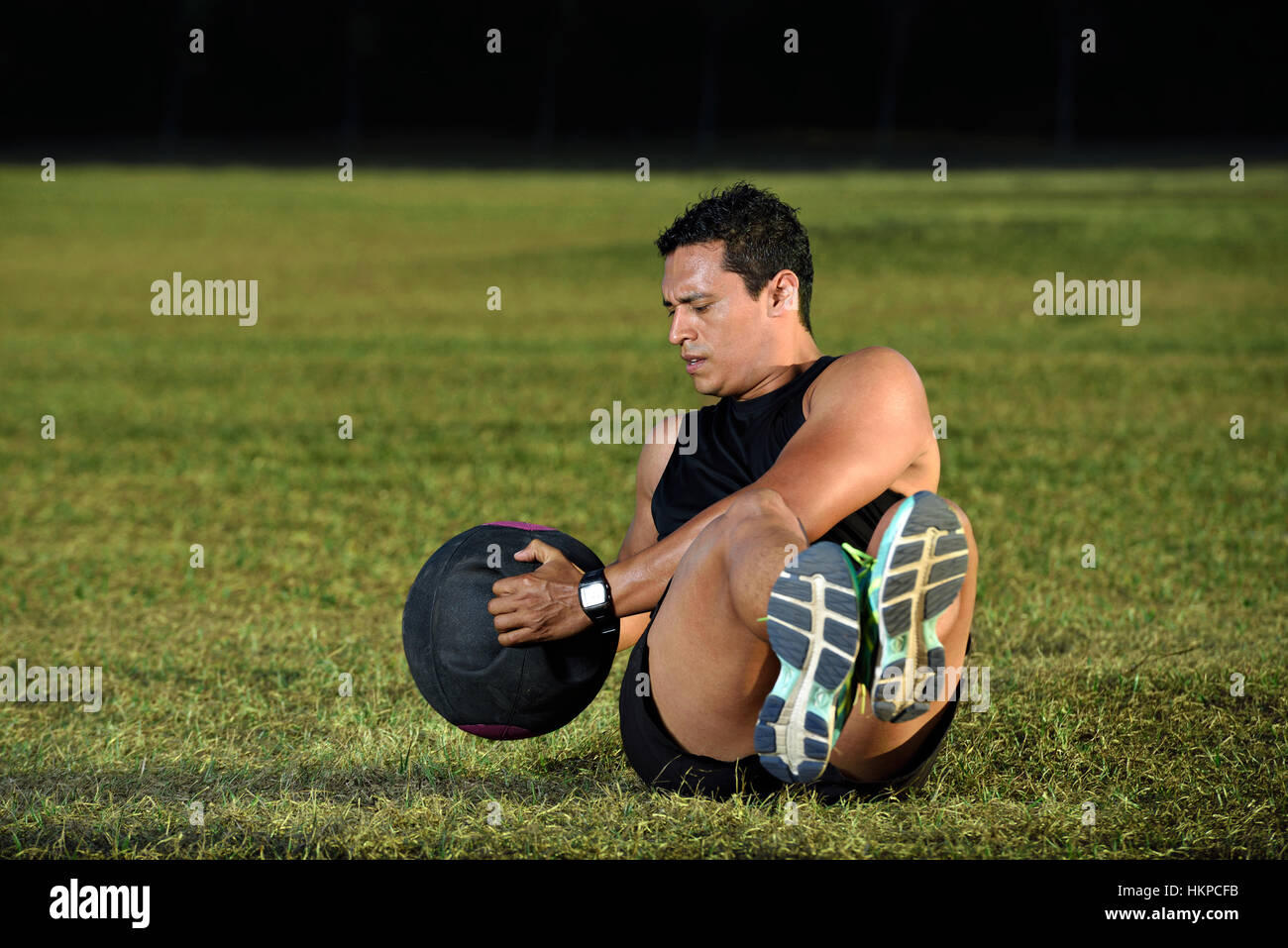 sport man workout on green grass lifting big ball Stock Photo - Alamy