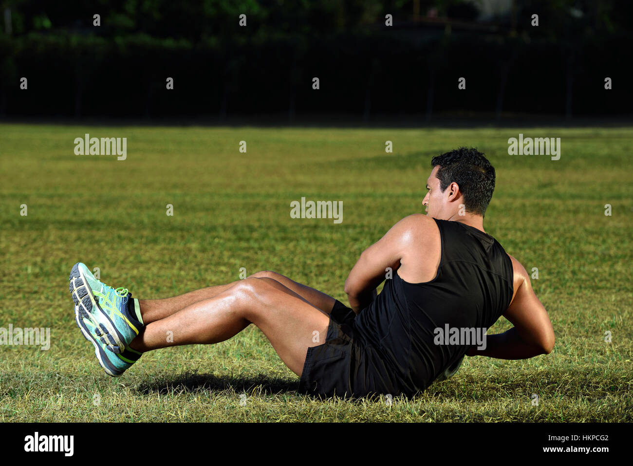 sporty guy working out on green grass park Stock Photo - Alamy