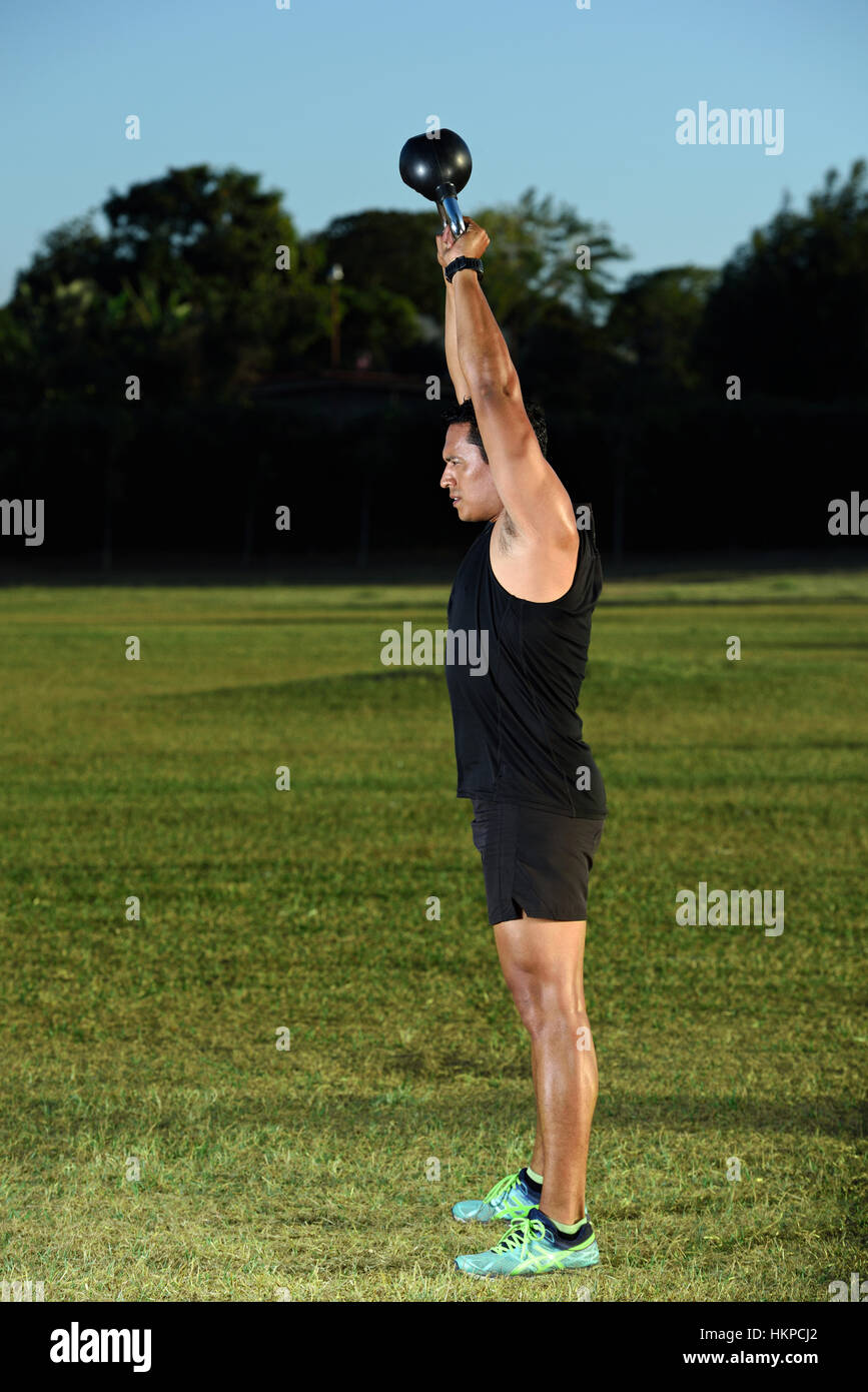 sportman workout outdoor lifting weight on green grass Stock Photo - Alamy