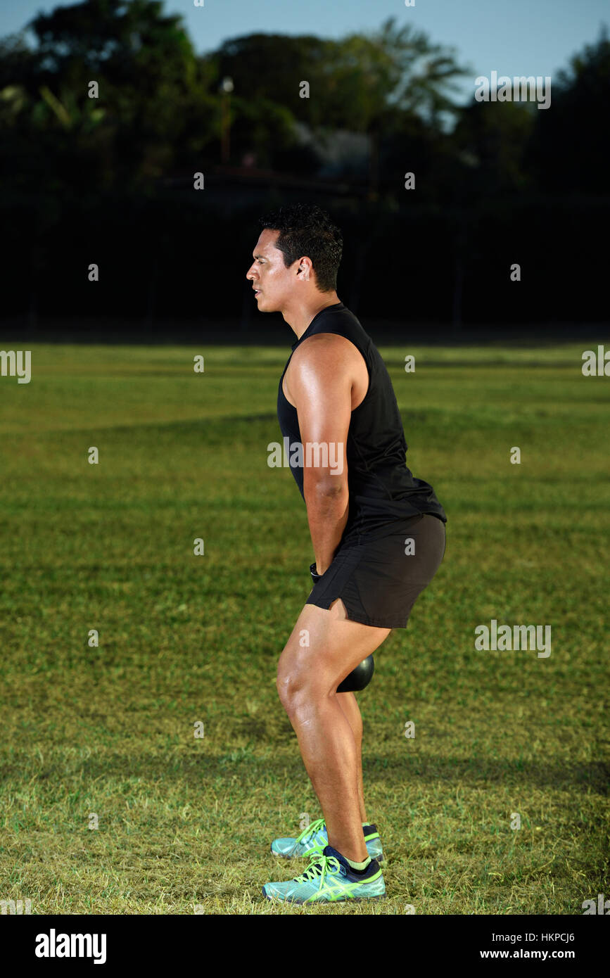 sport man lifting weight on green grass background Stock Photo - Alamy
