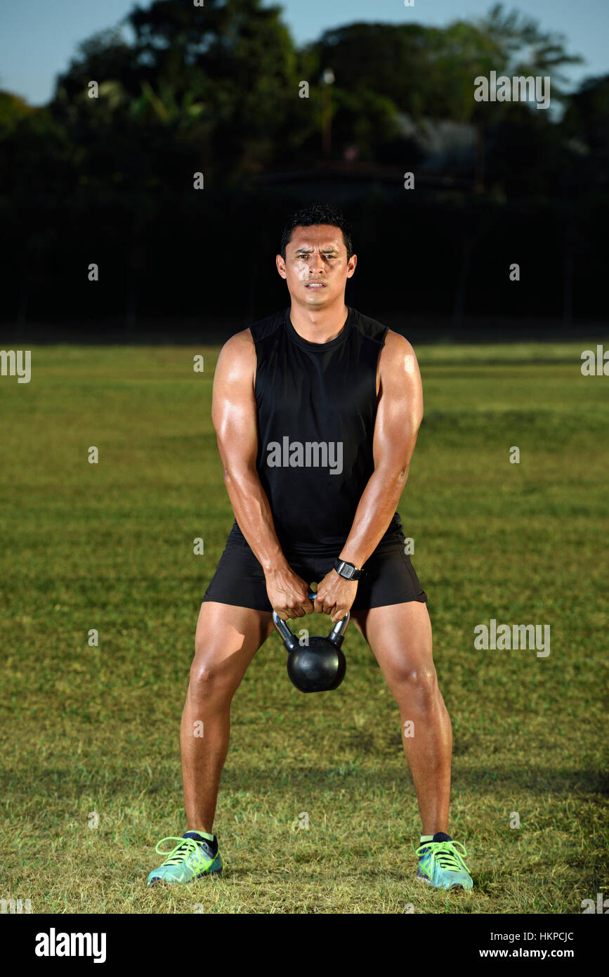 man doing workout lifting weight on green park grass Stock Photo - Alamy