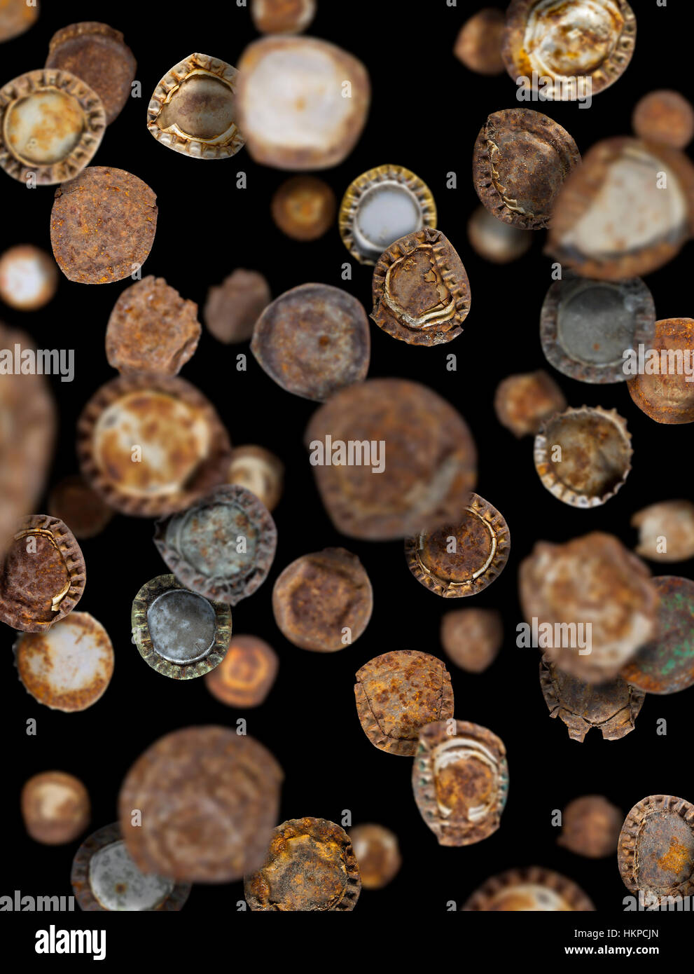 Lots of old rusty bottle caps falling like rain on a black background ...