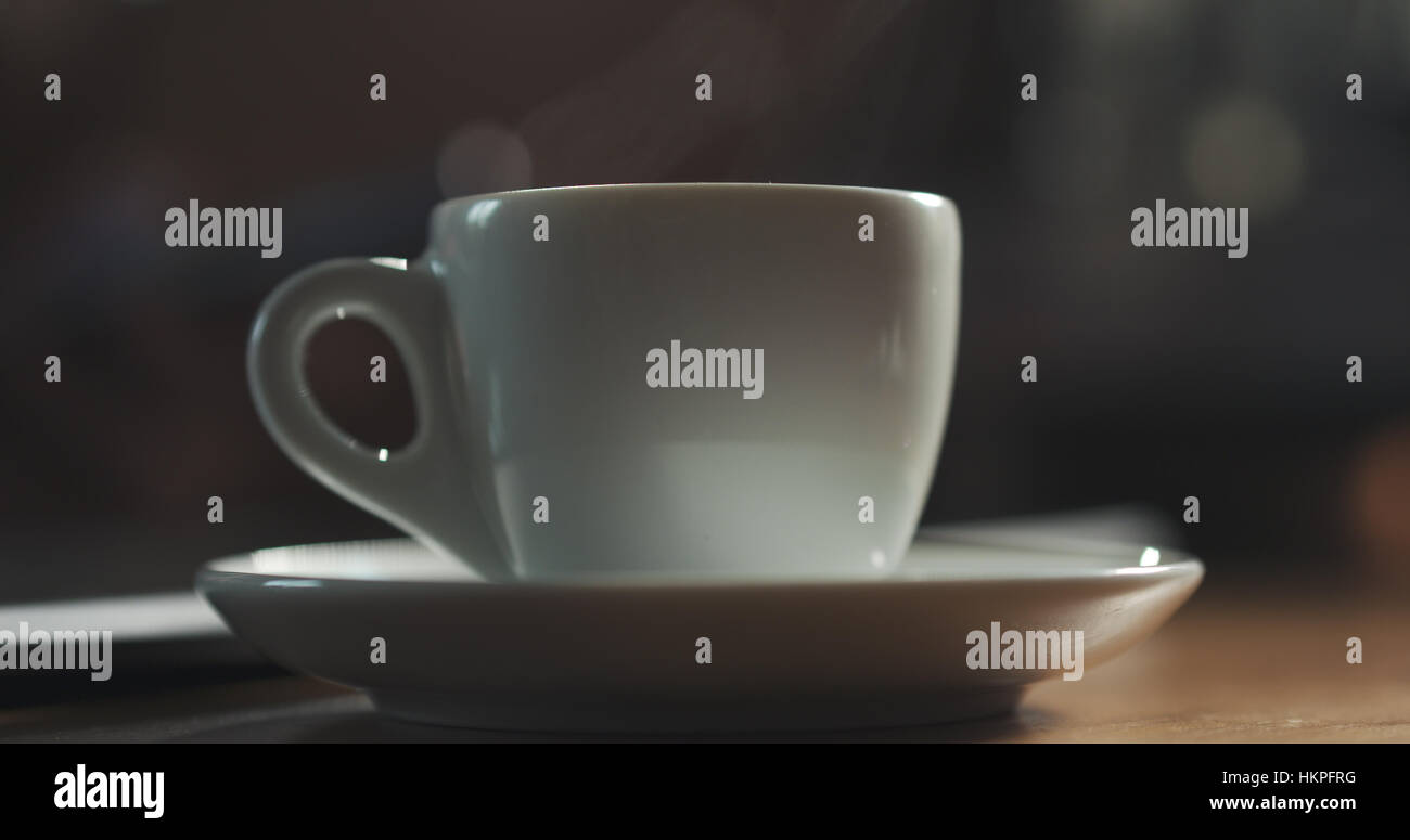 steam rising from espresso cup with fresh hot coffee shallow focus ...