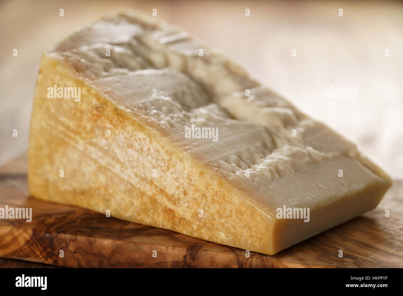 big chunk of italian parmesan cheese on wooden cutting board Stock ...