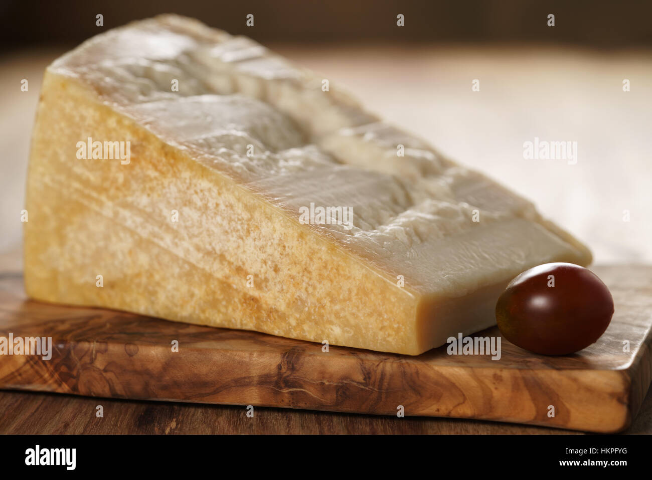 big chunk of italian parmesan cheese on wooden cutting board Stock ...