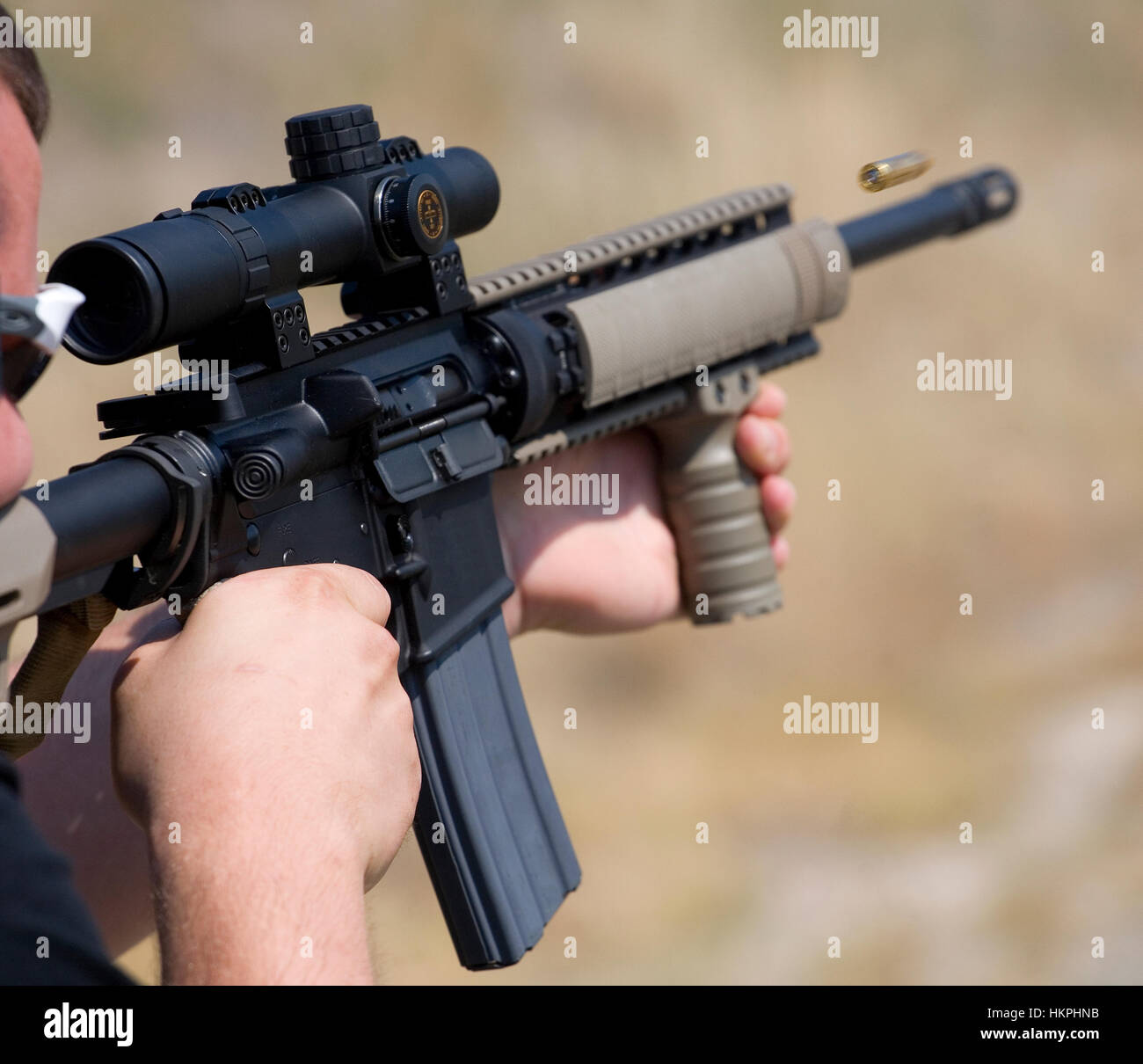 Shooter who has just taken a shot with an assault rifle Stock Photo - Alamy