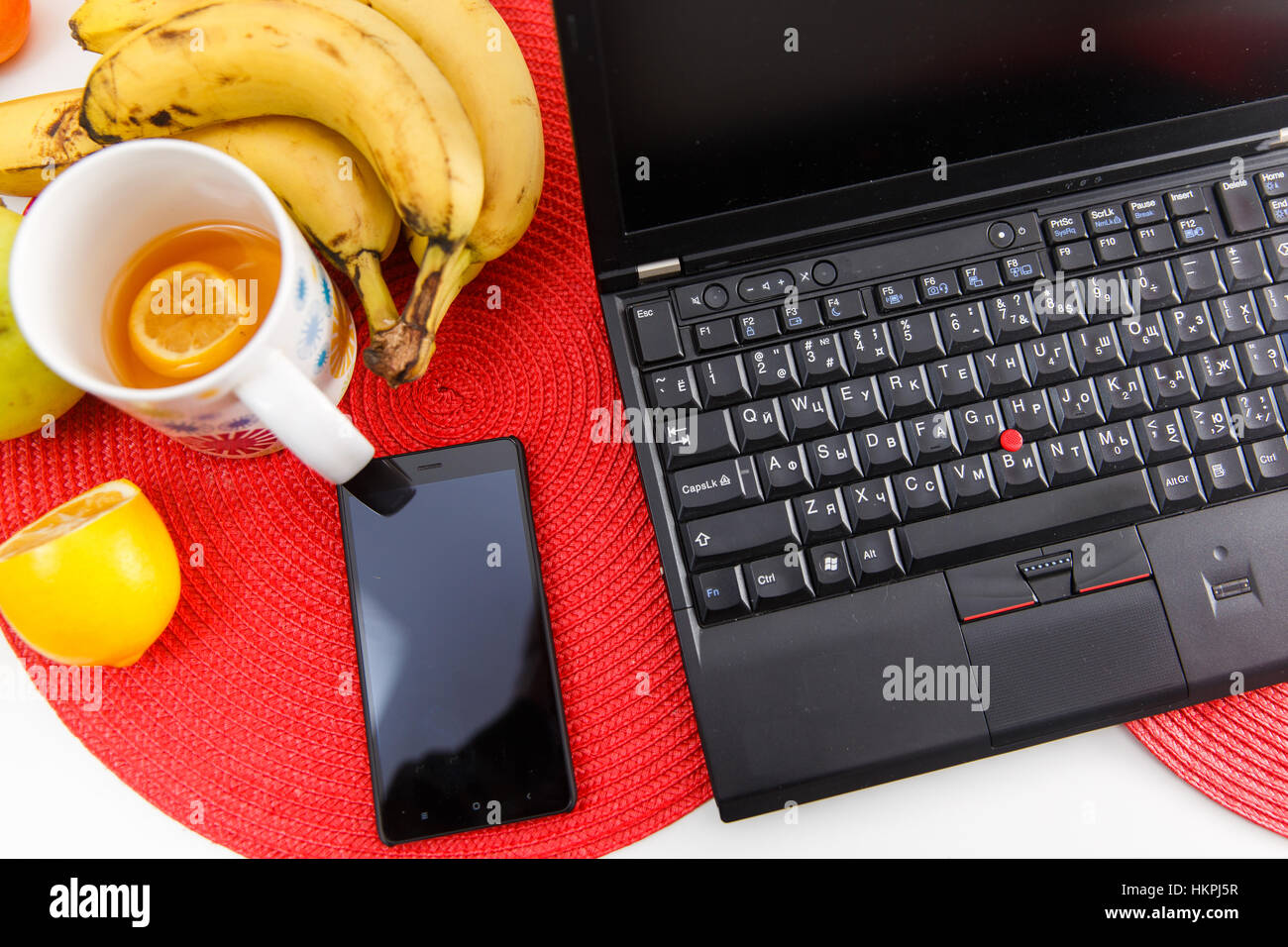 Table with tea, phone, laptop Stock Photo - Alamy
