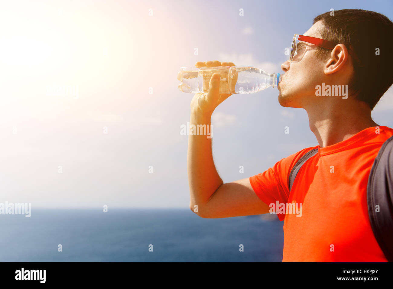 Man drinks water near sea Stock Photo - Alamy