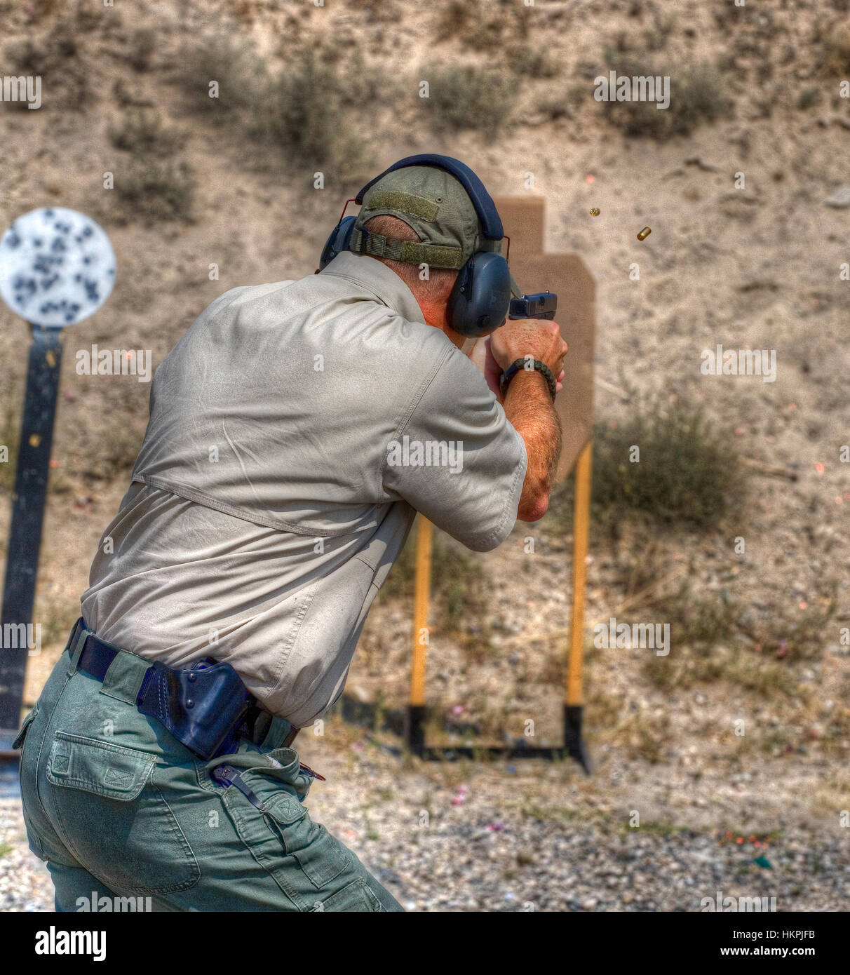 Handgun shooter practicing while on the shooting range Stock Photo - Alamy
