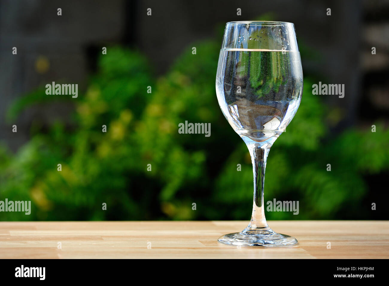 tall glass with water on green park background Stock Photo - Alamy