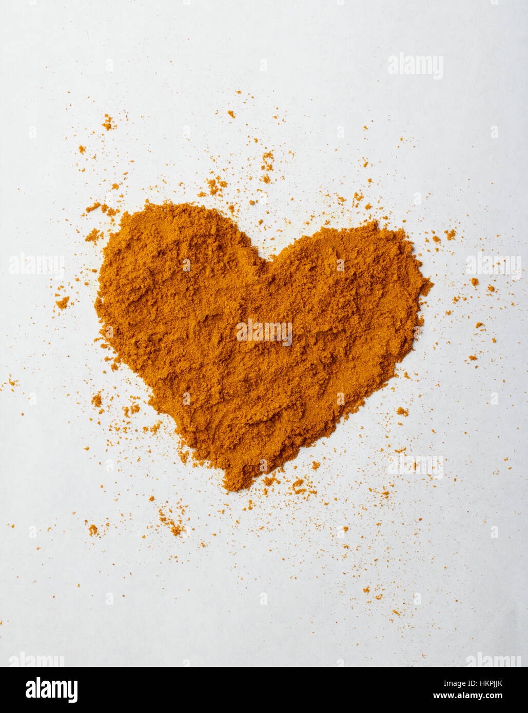 Ground turmeric or curry powder formed into the shape of a heart on a ...