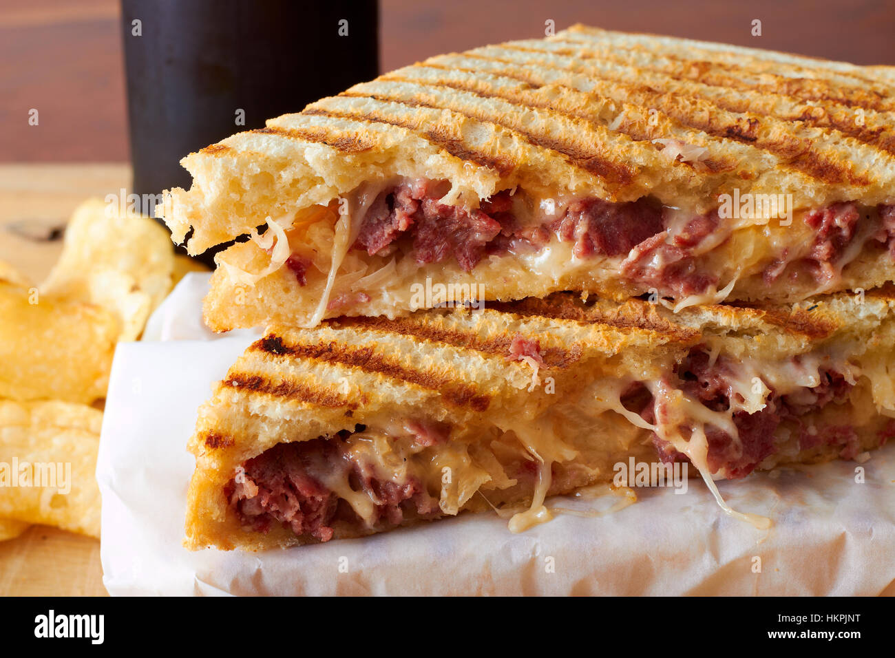 A hot grilled panini sandwich with meat and melting cheese. The ...