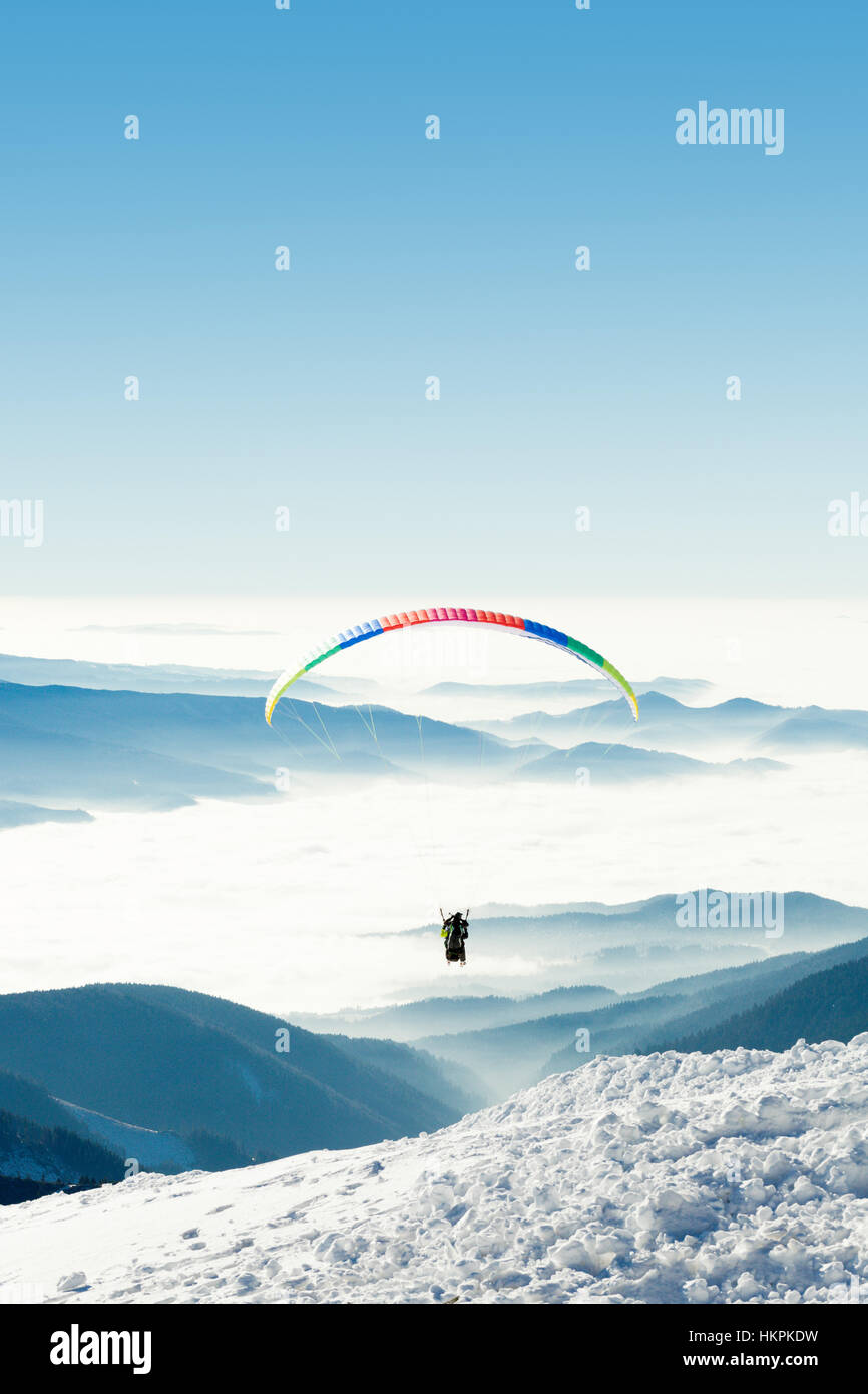 Paraglider in the sky above a snowy mountain Stock Photo - Alamy