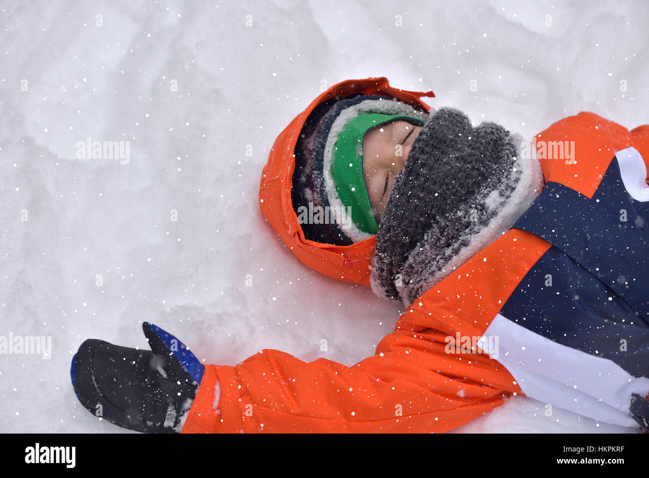 Funny little kid boy in colorful clothes playing outdoors during ...
