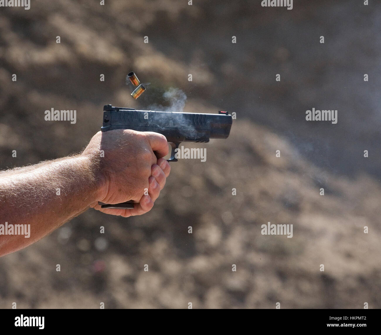Two shots delivered from a semi automatic handgun with brass flying ...