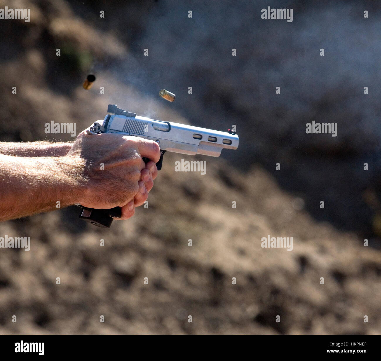 Handgun pouring out smoke with two pieces of brass in the air Stock ...