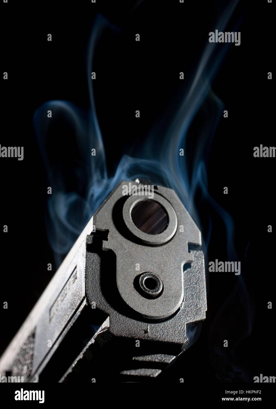 handgun that is smoking with a dark background Stock Photo - Alamy
