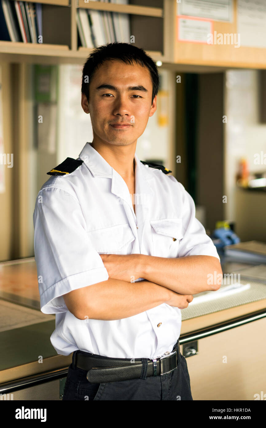 Young Chinese navigator on bridge, navigating his ship at sea Stock ...