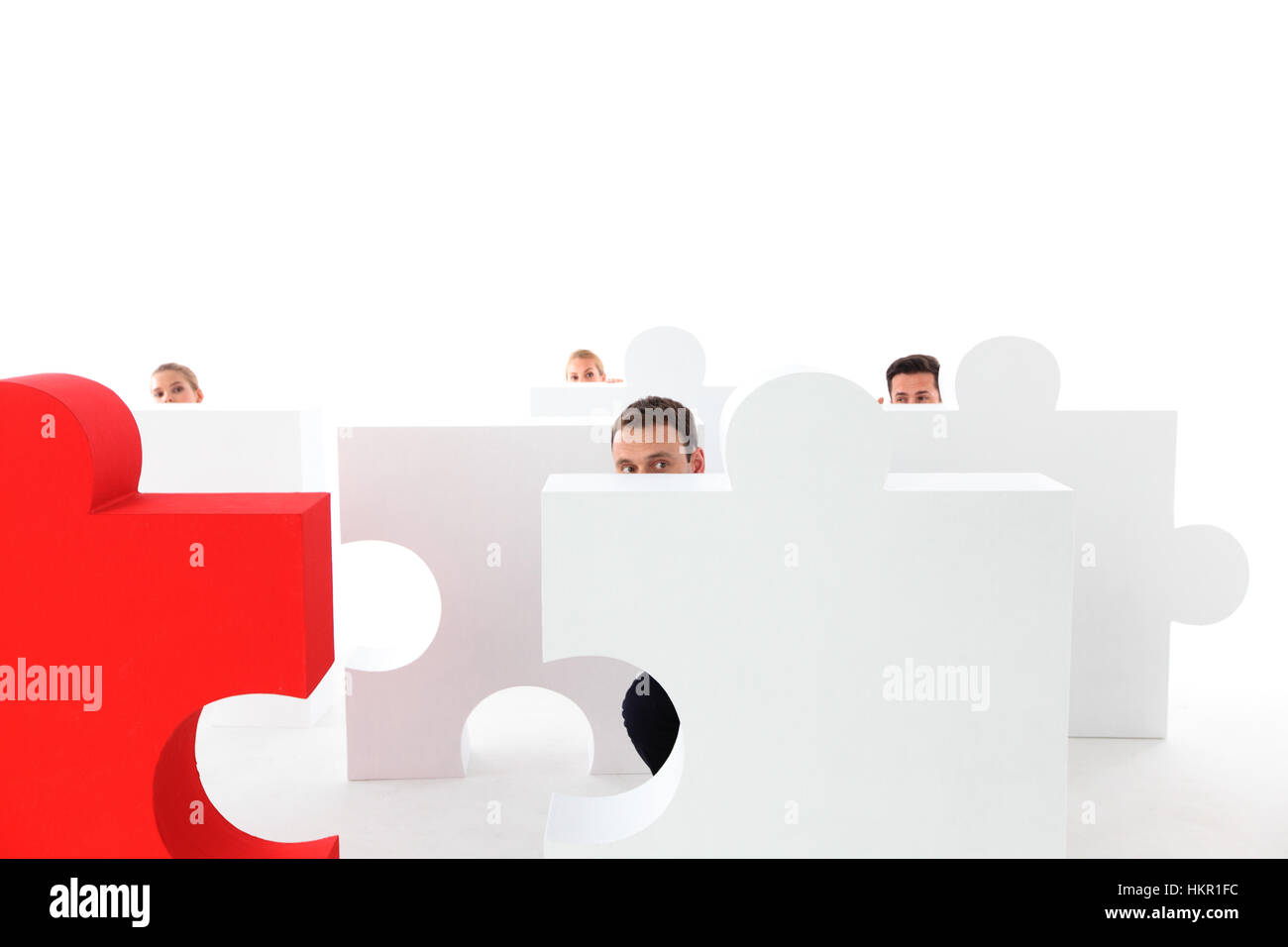 Business people hiding behind puzzle pices isolated on white background ...