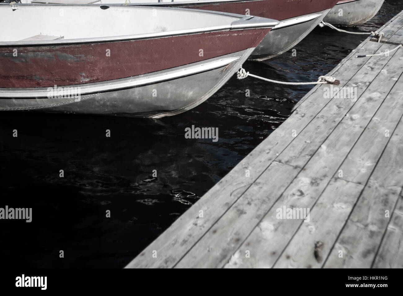 Aluminum fishing boats are tied up to a dock waiting to be used Stock ...