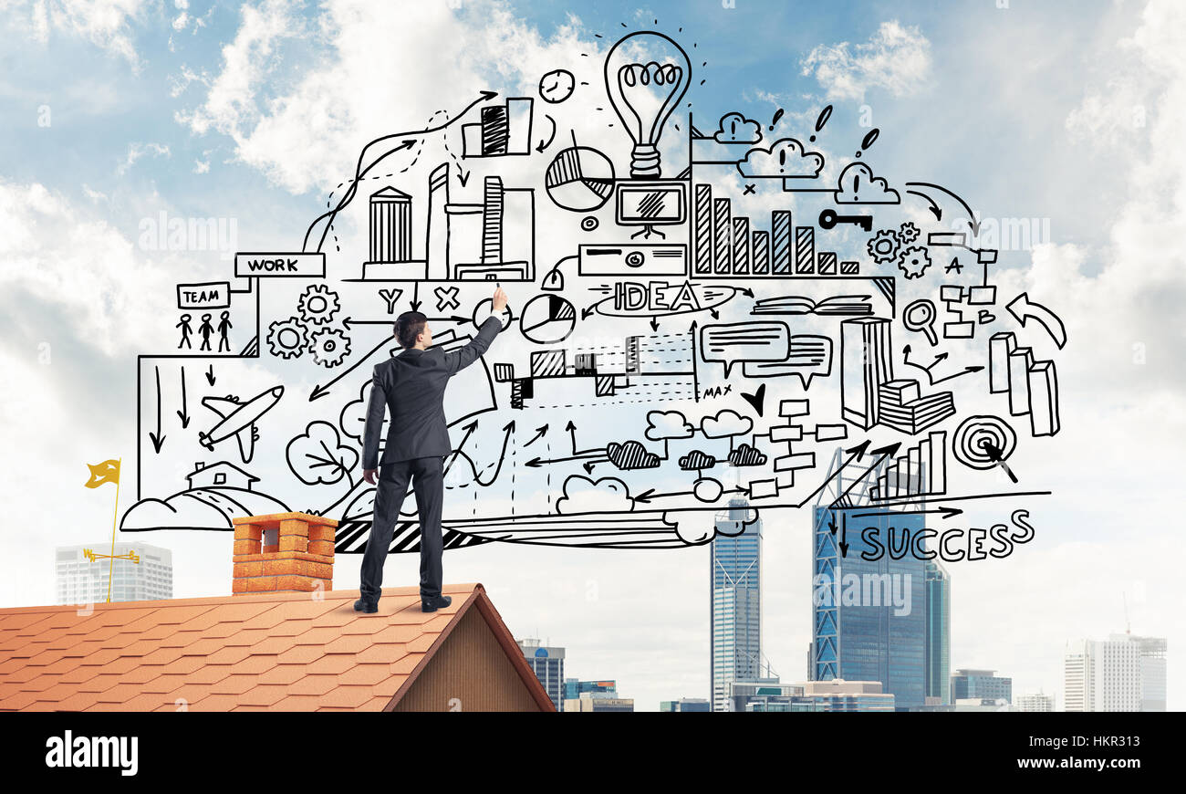 Rear view of businessman on house roof drawing his new business Stock ...
