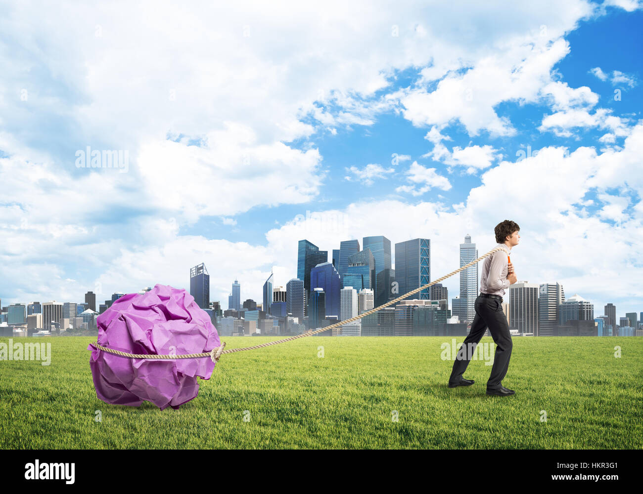 Man pulling with effort big crumpled ball of paper as creativity sign ...